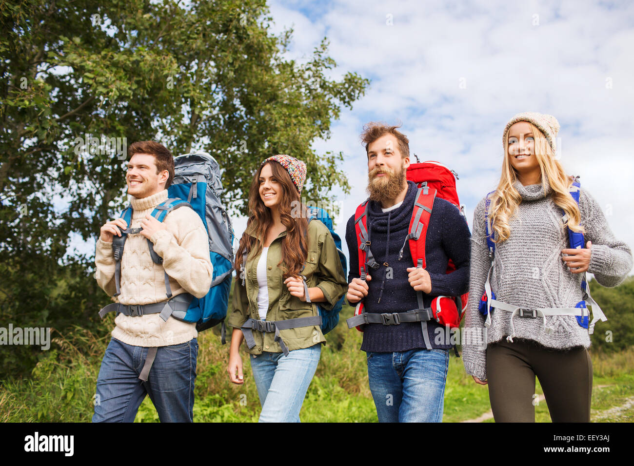 group of smiling friends with backpacks hiking Stock Photo - Alamy