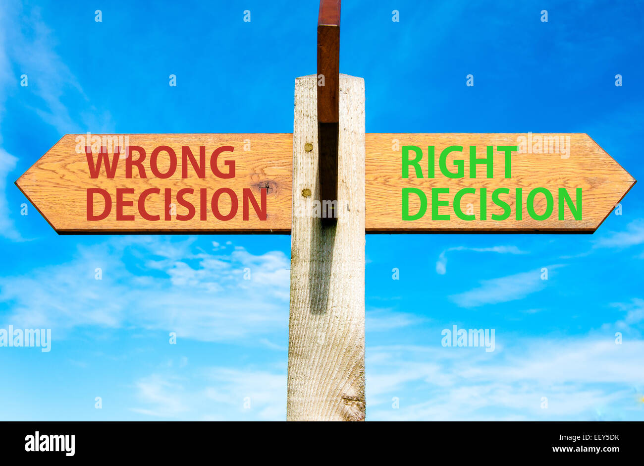 Wooden signpost with two opposite arrows over clear blue sky, Right ...