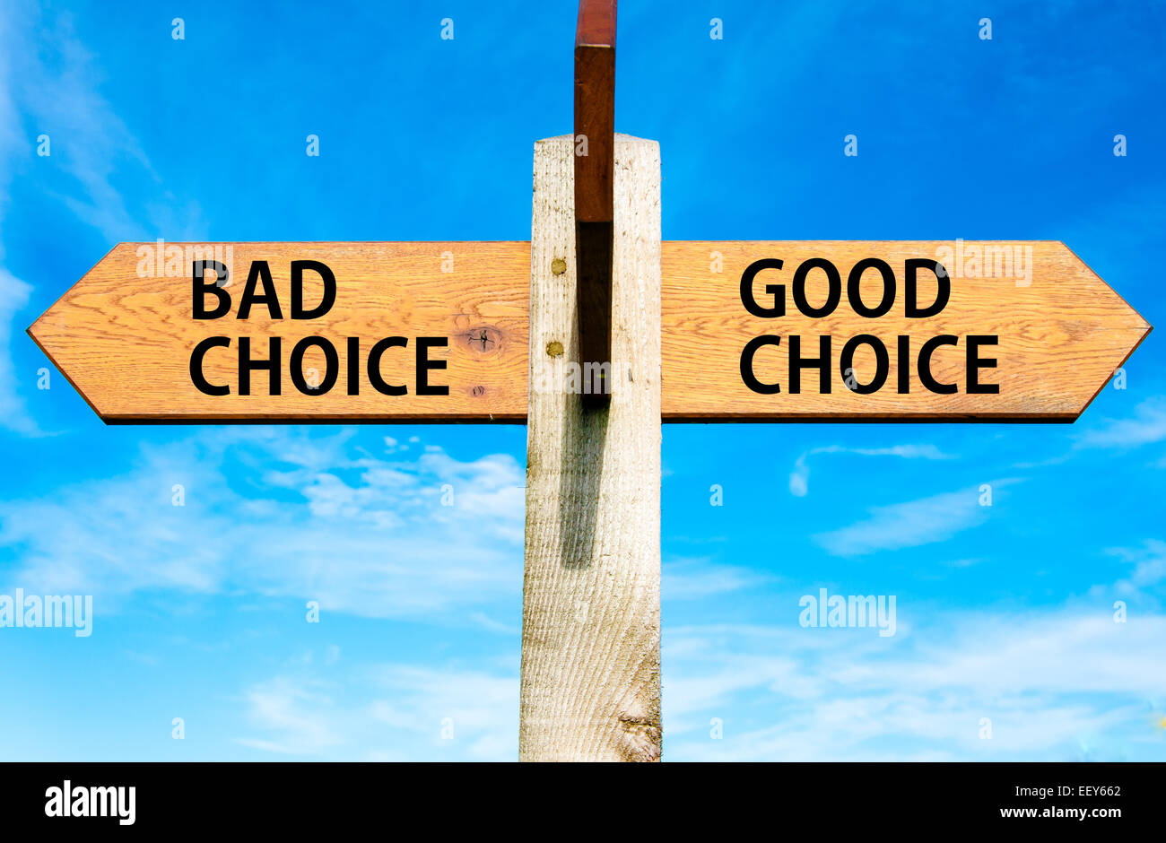 Wooden signpost with two opposite arrows over clear blue sky, Bad ...