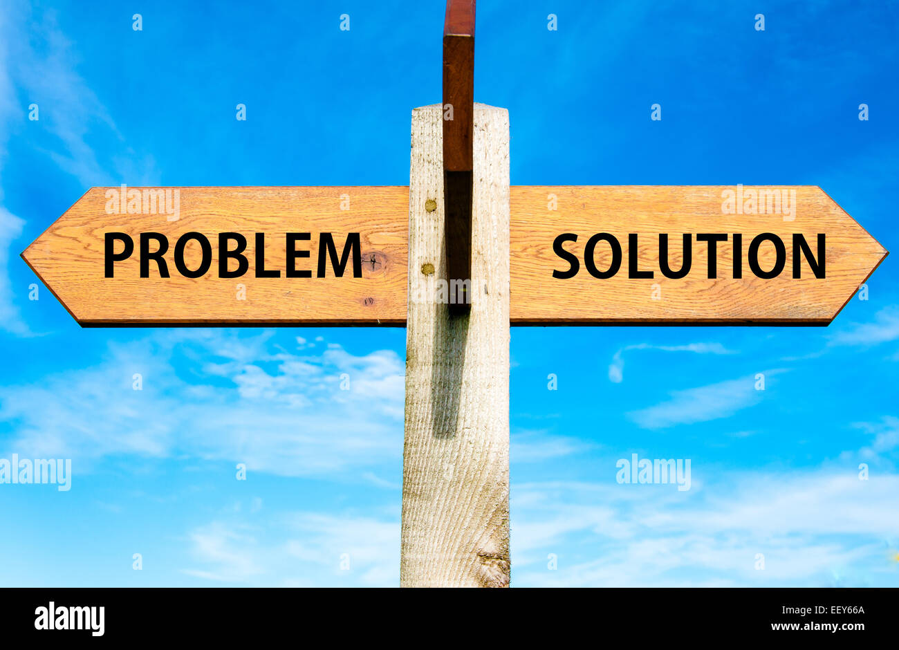 Wooden signpost with two opposite arrows over clear blue sky, Problem ...