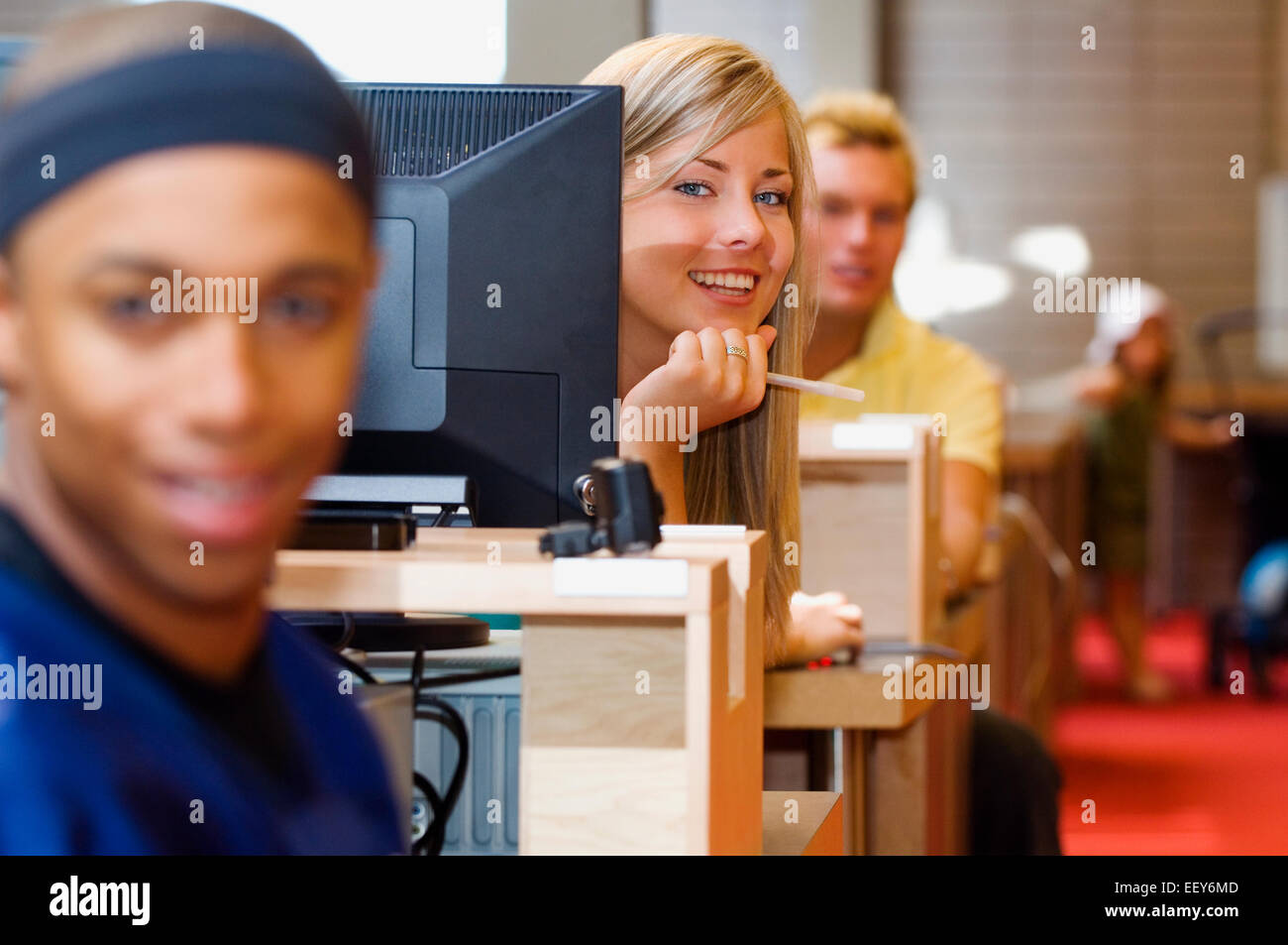 Young adults in a library using computer terminals Stock Photo - Alamy