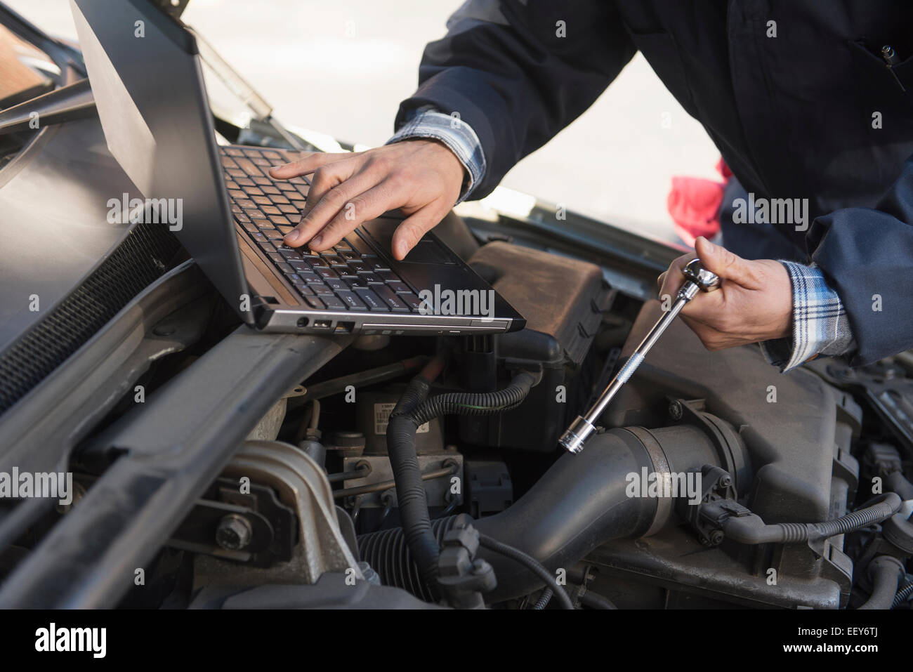 Mechanic using laptop while repairing car Stock Photo - Alamy