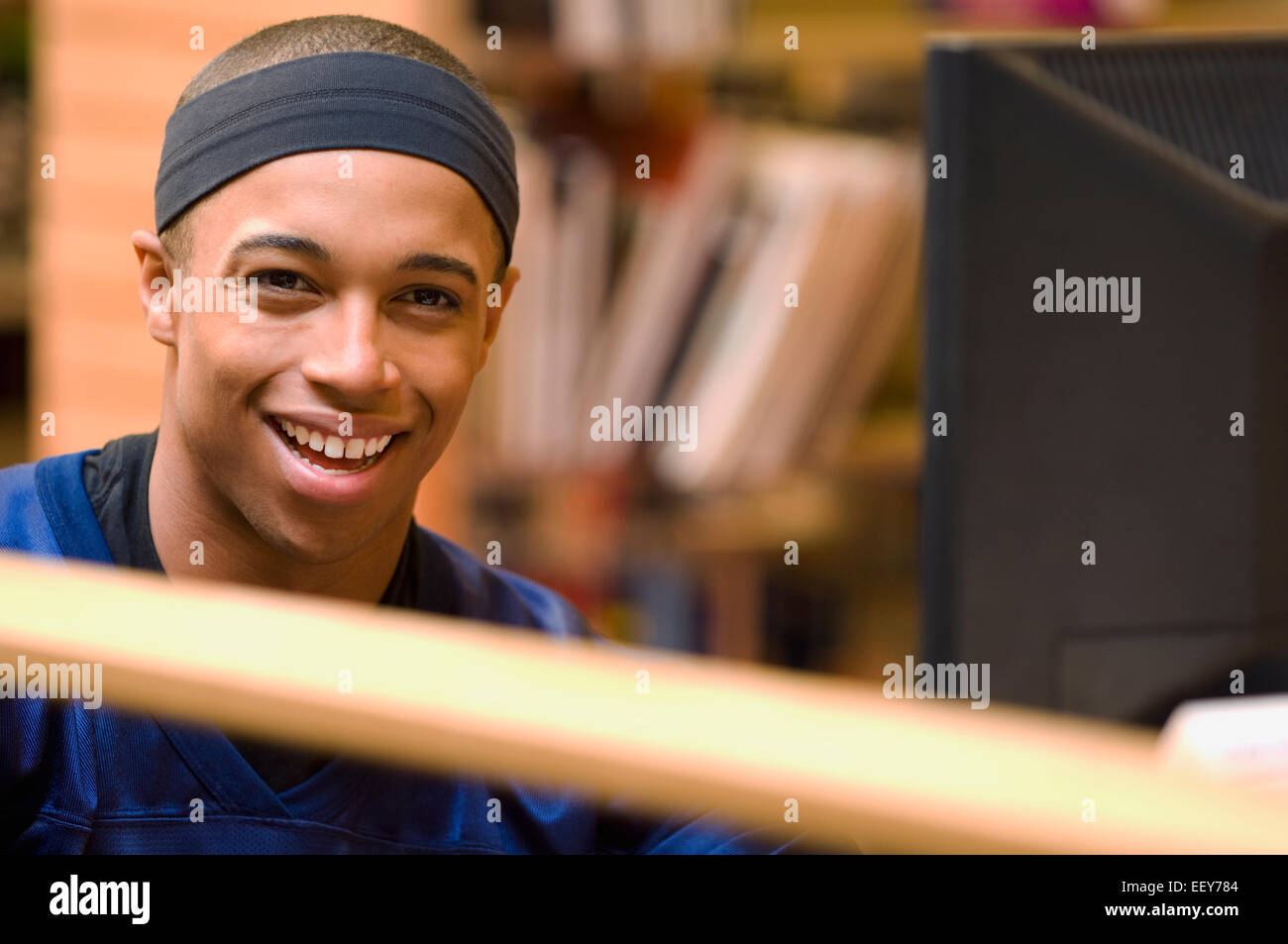 Young man in a library at a computer terminal Stock Photo - Alamy
