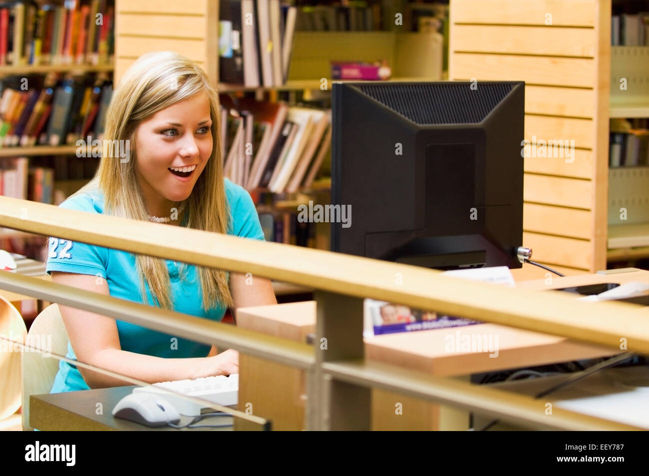 Young woman in a library at a computer terminal Stock Photo - Alamy