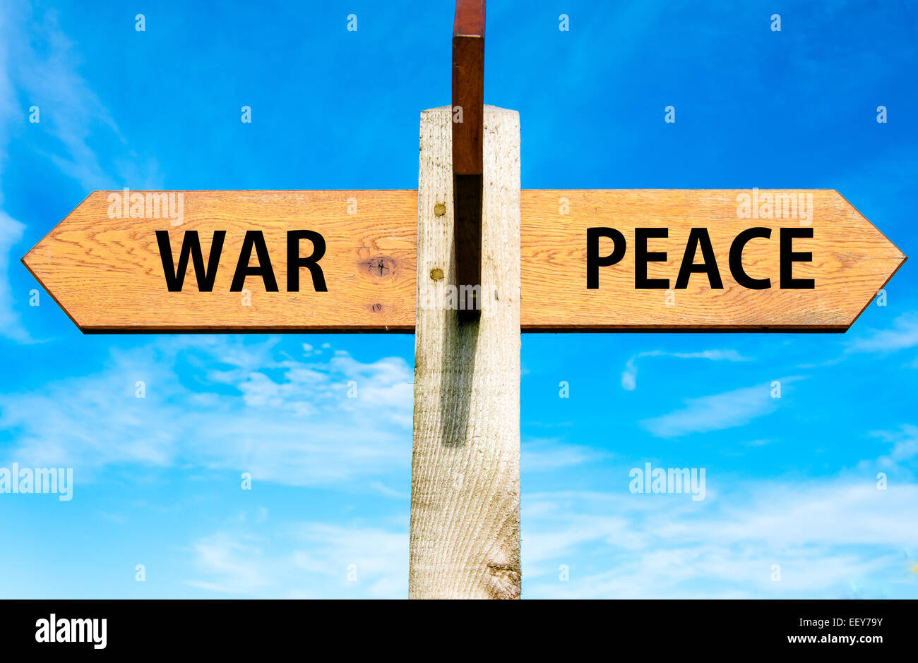 Wooden signpost with two opposite arrows over clear blue sky, War ...