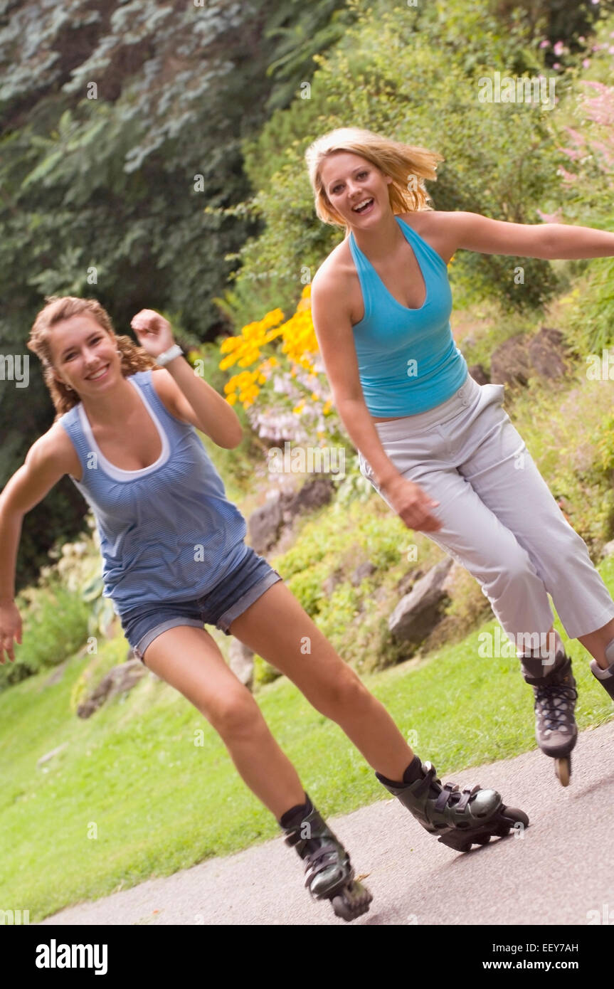 Two women inline skating at a park Stock Photo - Alamy