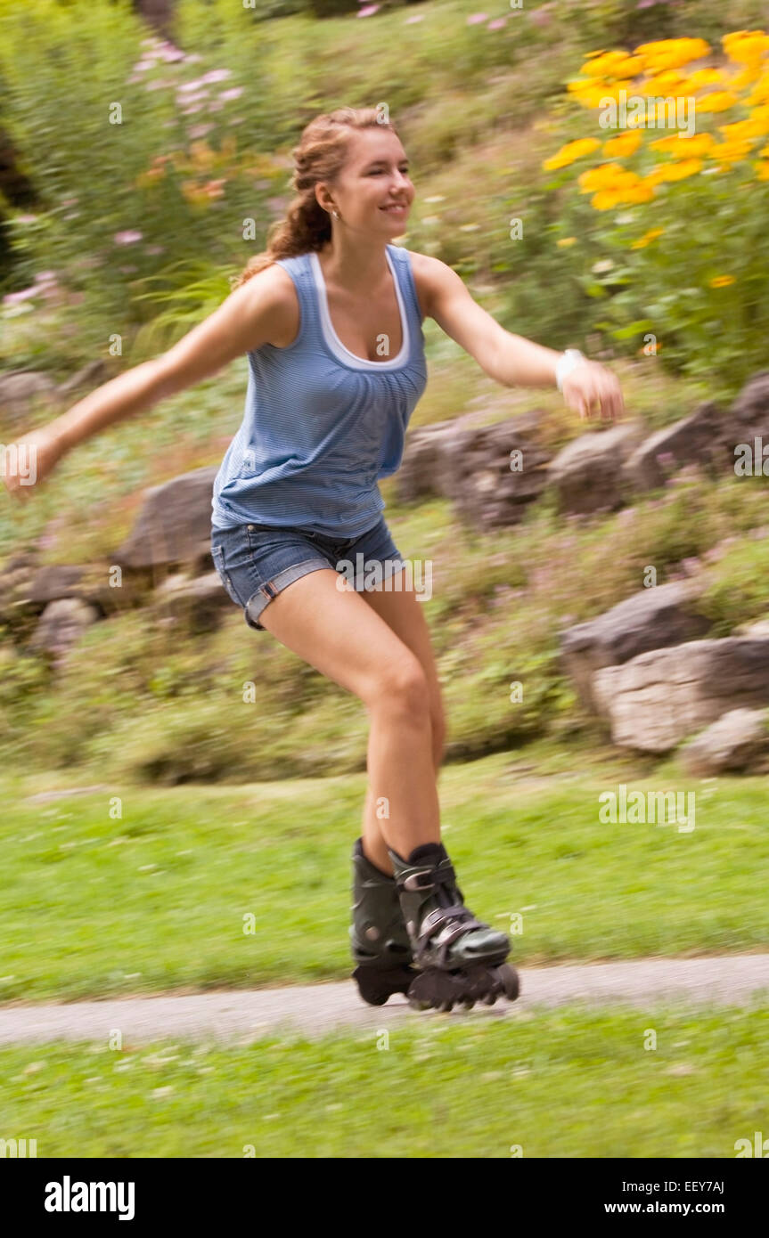 Woman inline skating at a park Stock Photo - Alamy