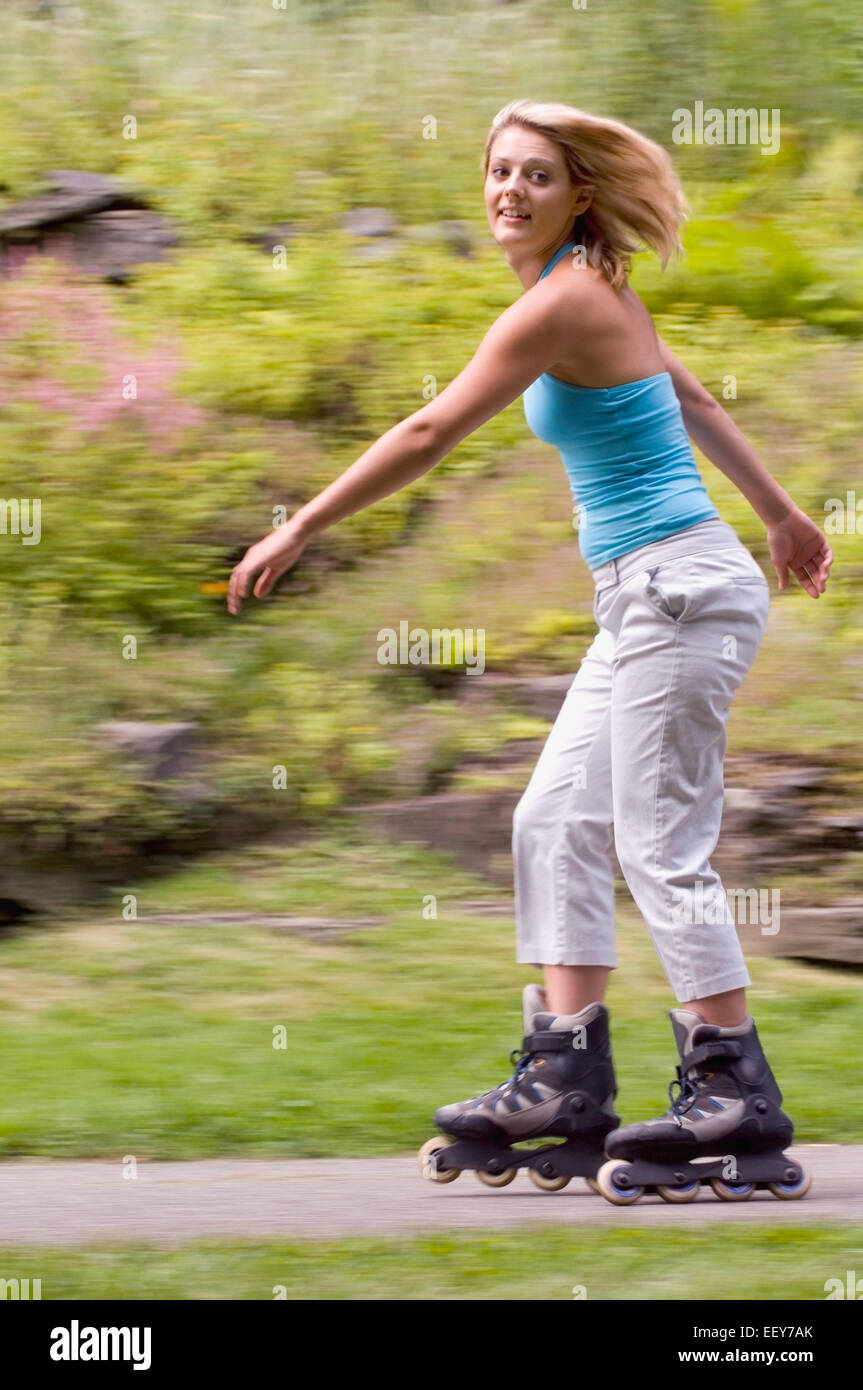 Woman inline skating at a park Stock Photo - Alamy