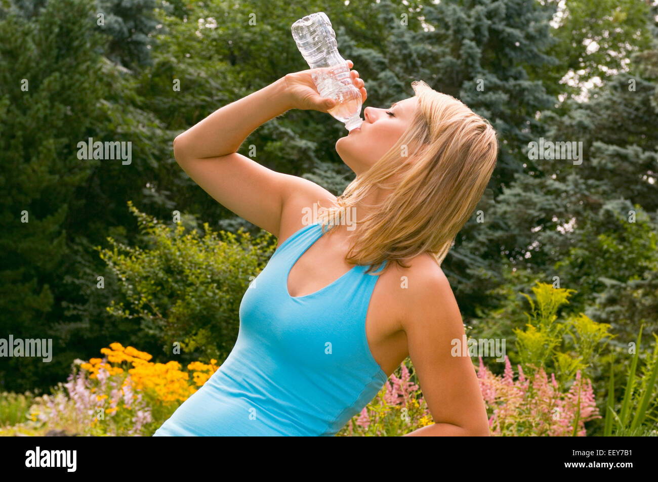 Woman drinking water at a park Stock Photo - Alamy