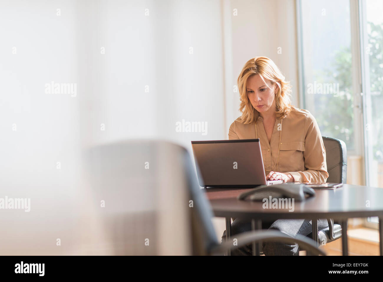 Three business people using computers in office Stock Photo - Alamy