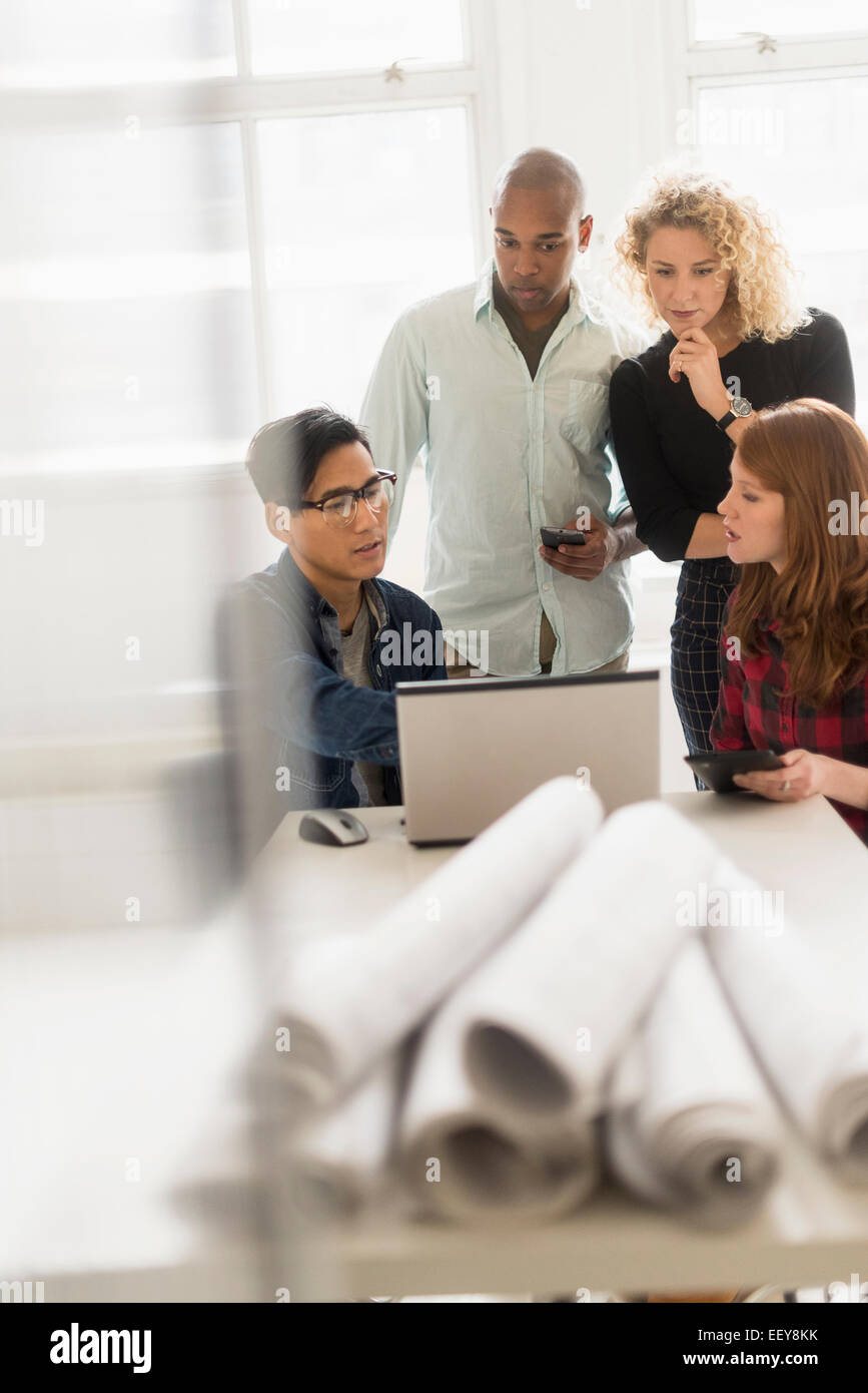 Friends working on project in office Stock Photo - Alamy