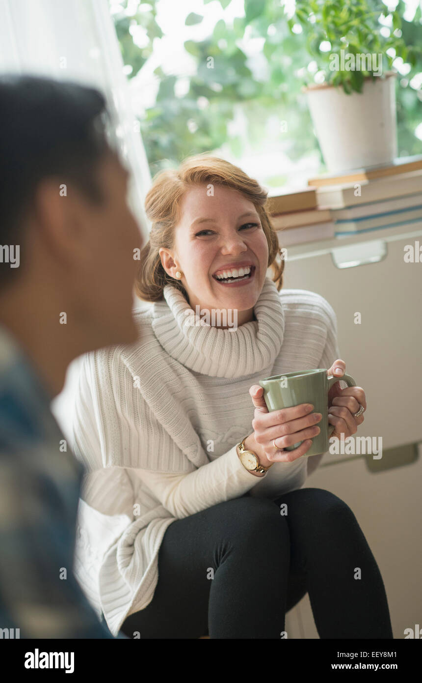 Smiling woman sitting and holding mug Stock Photo - Alamy