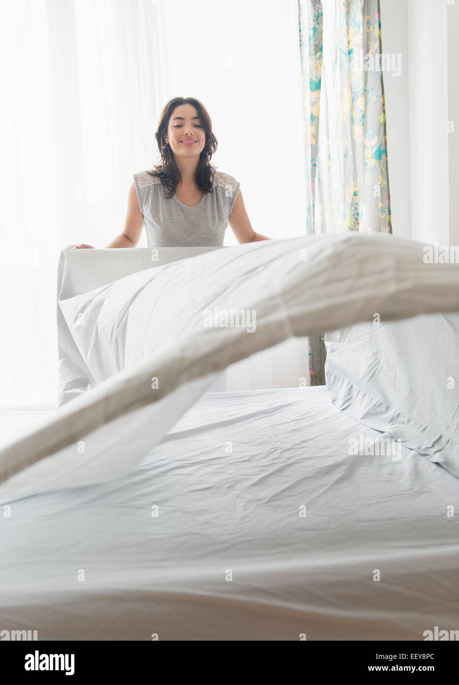 Young woman making bed Stock Photo - Alamy