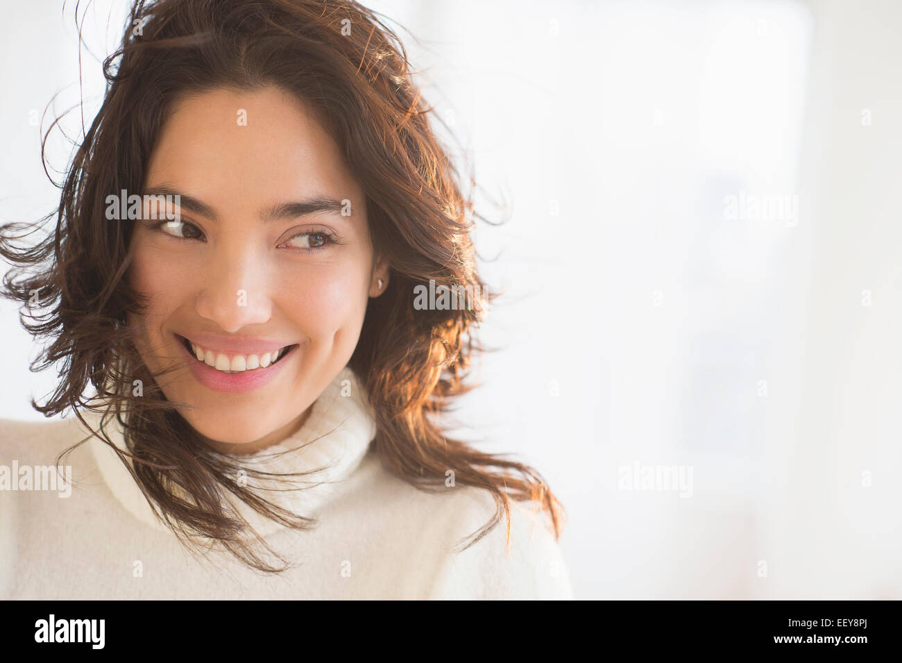 Smiling young woman looking sideways Stock Photo - Alamy