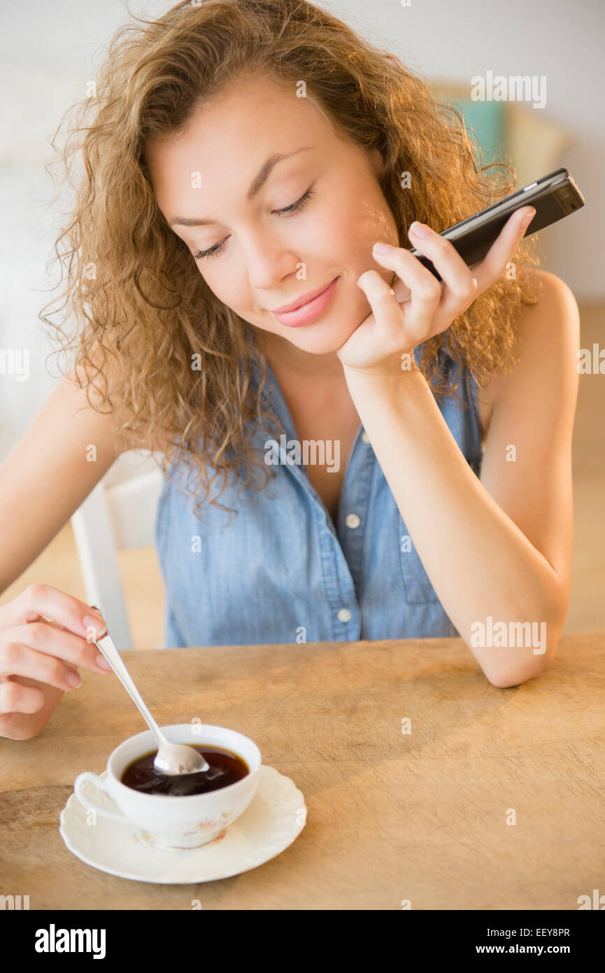 Young woman looks phone sitting hi-res stock photography and images - Alamy