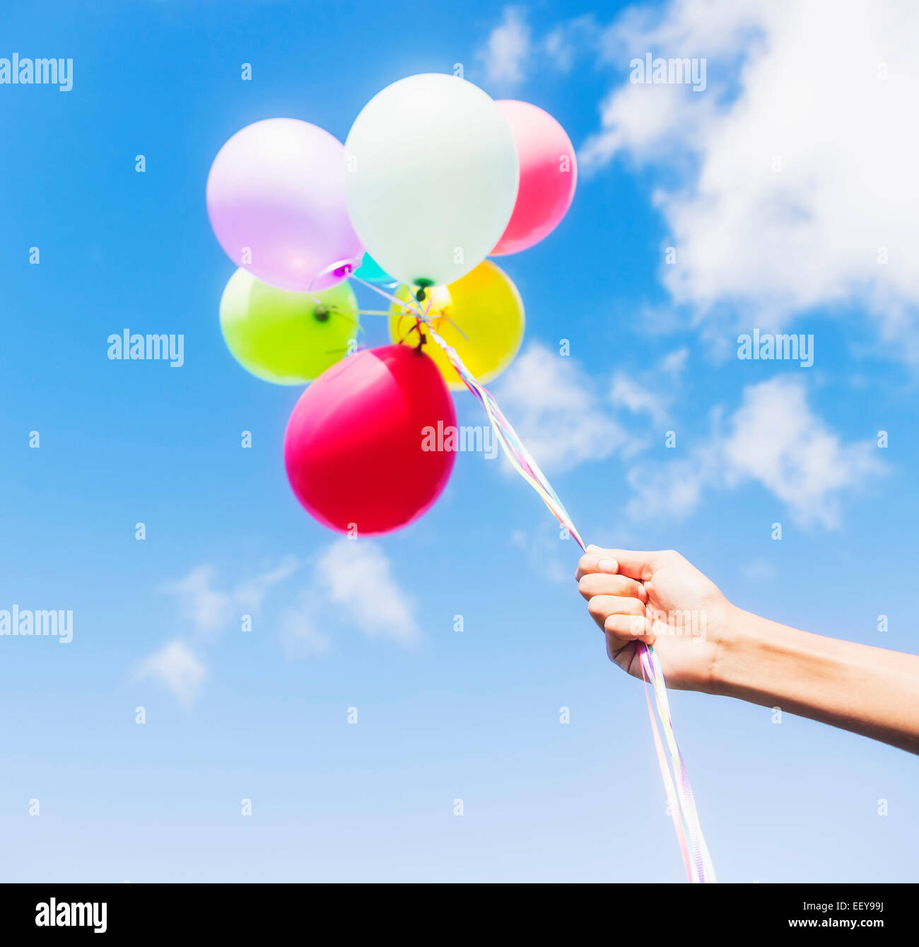 Young man holding balloons Stock Photo - Alamy