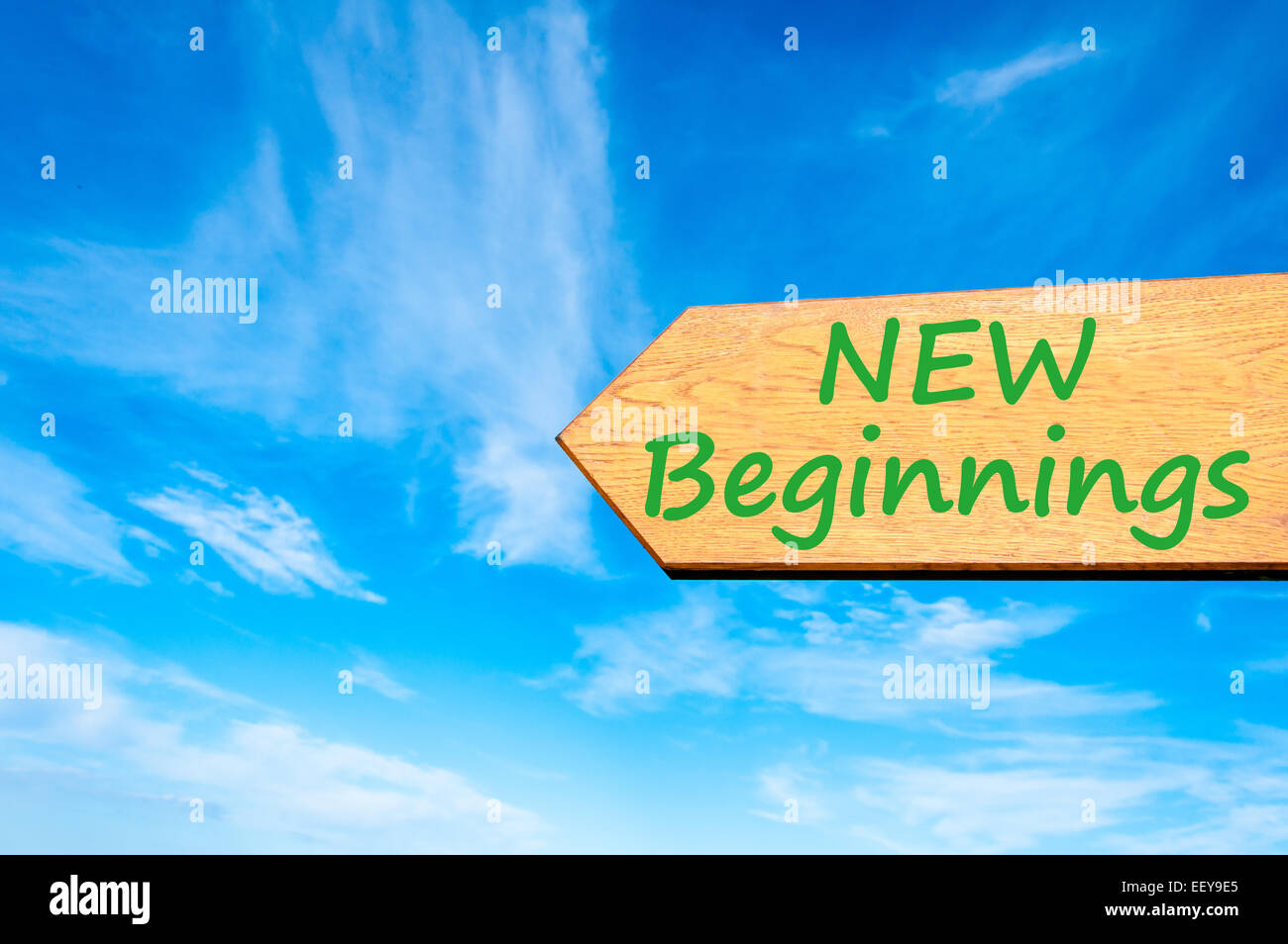 Wood arrow sign against clear blue sky with New Beginnings message, Life change conceptual image ...