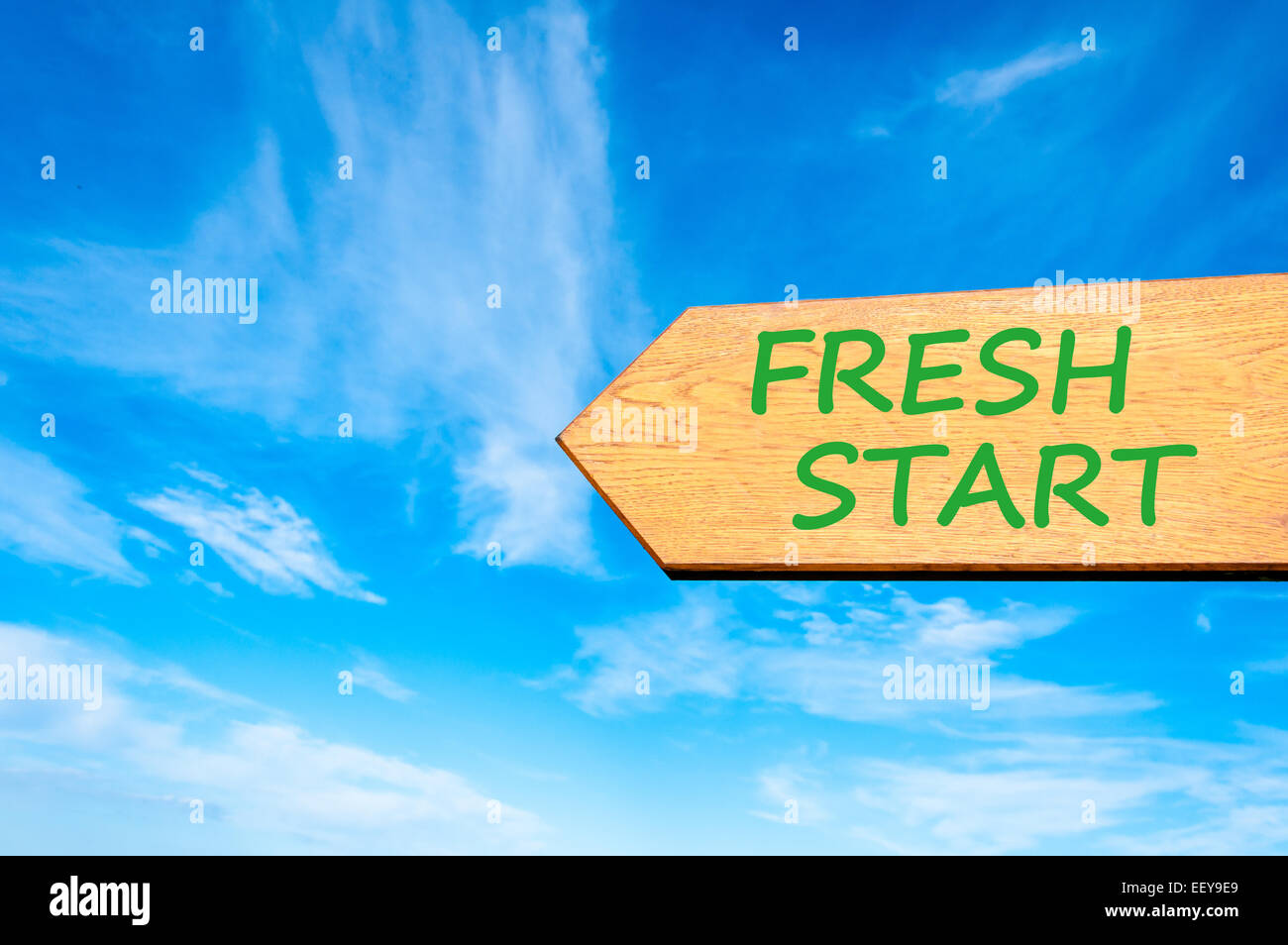 Wood arrow sign against clear blue sky with Fresh Start, Life change ...