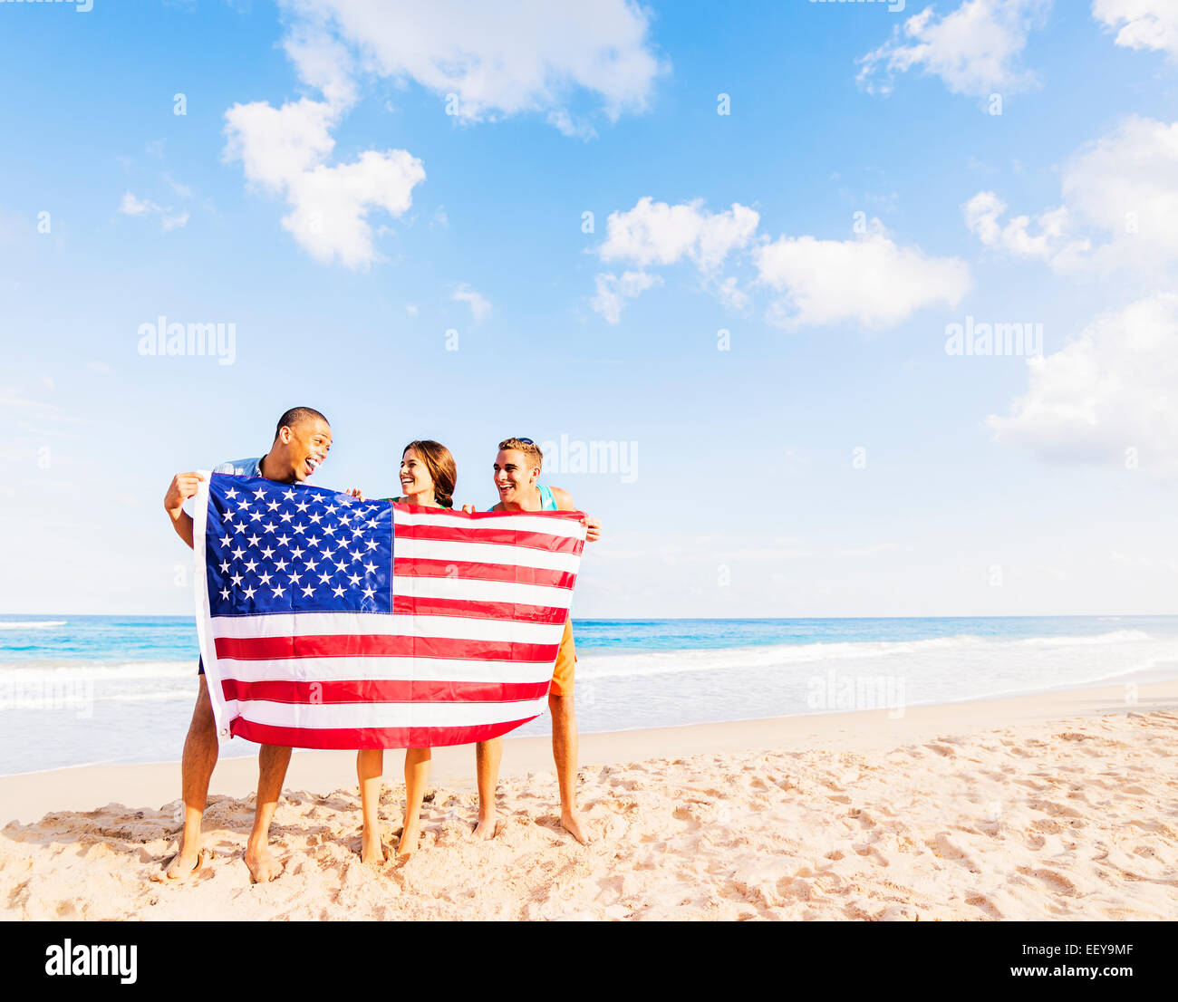 USA, Florida, Jupiter, Young people holding American flag on beach ...