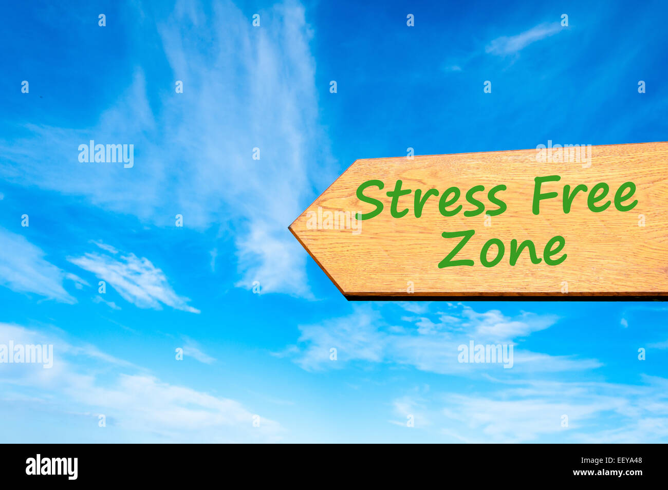 Wood arrow sign against clear blue sky with Stress Free zone message ...