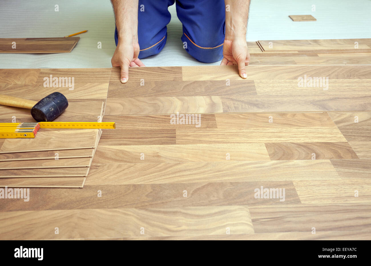 Carpenter installing wooden floor - home improvement Stock Photo - Alamy