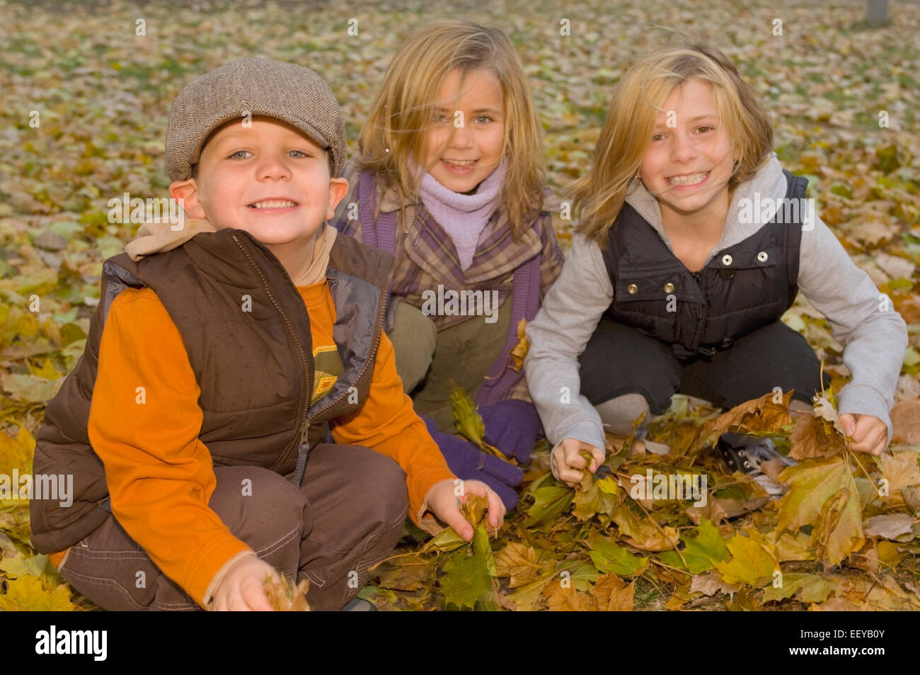 Three young children playing outdoors Stock Photo - Alamy