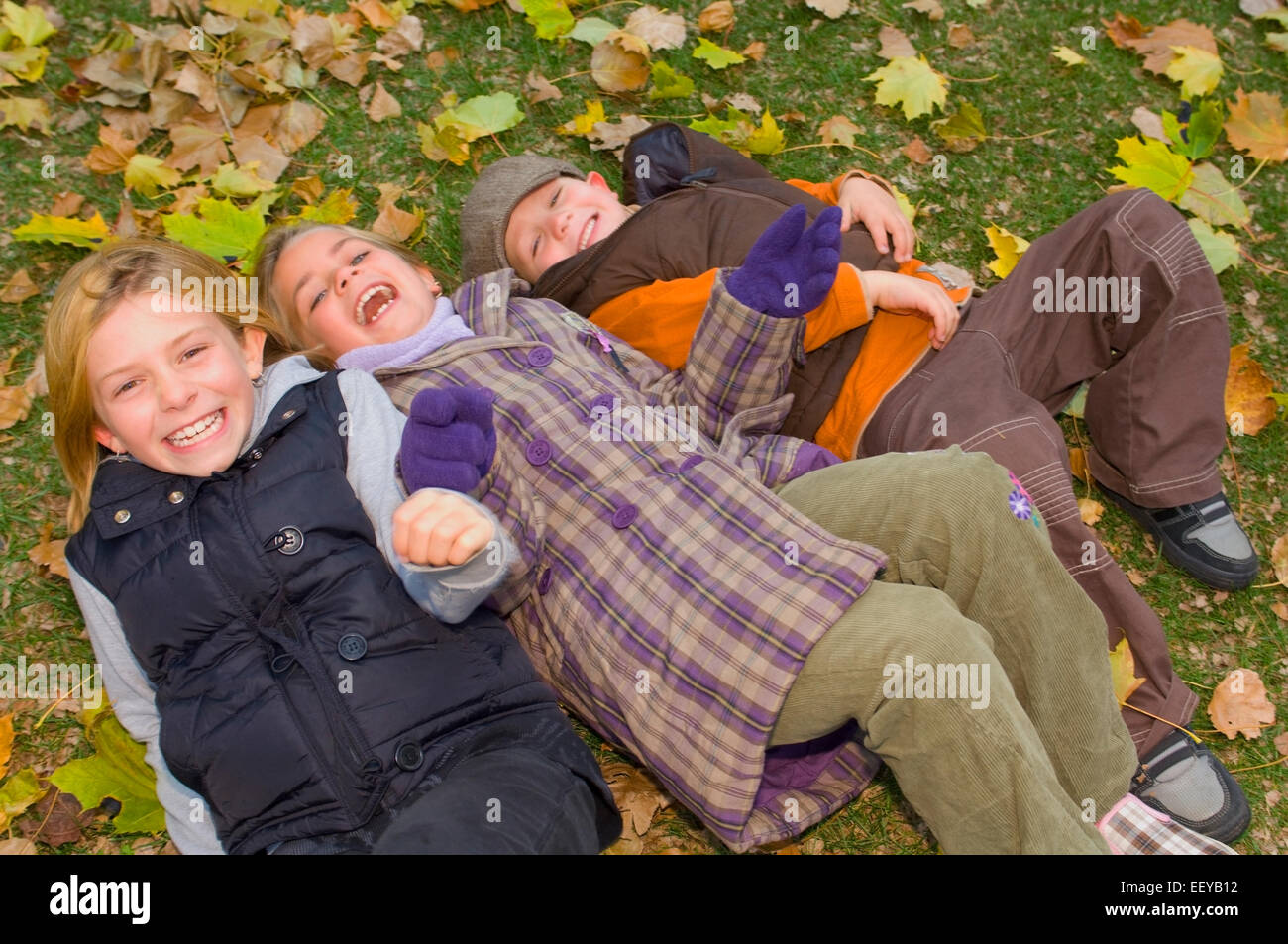 Three young children playing outdoors Stock Photo - Alamy
