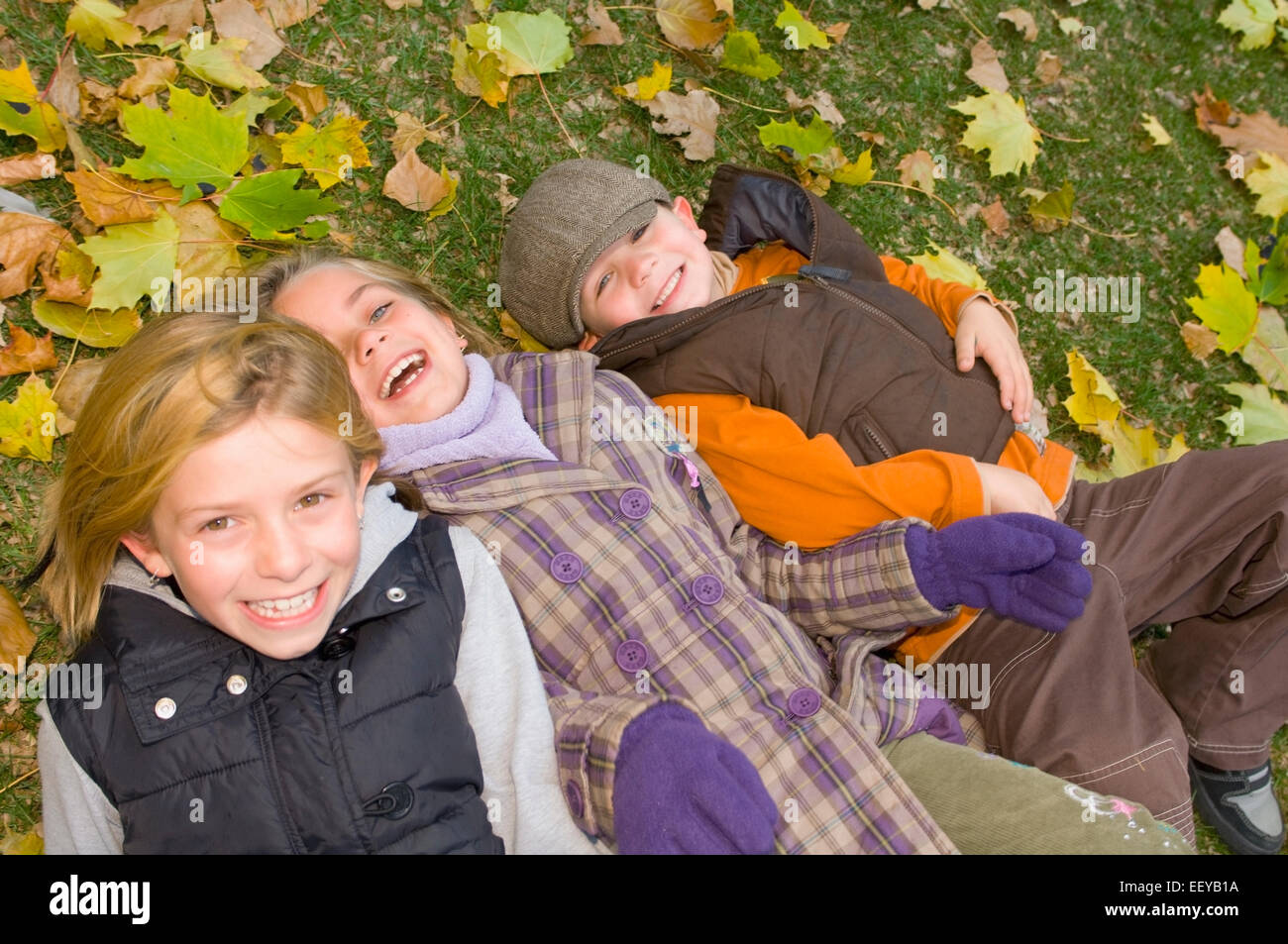 Three young children playing outdoors Stock Photo - Alamy