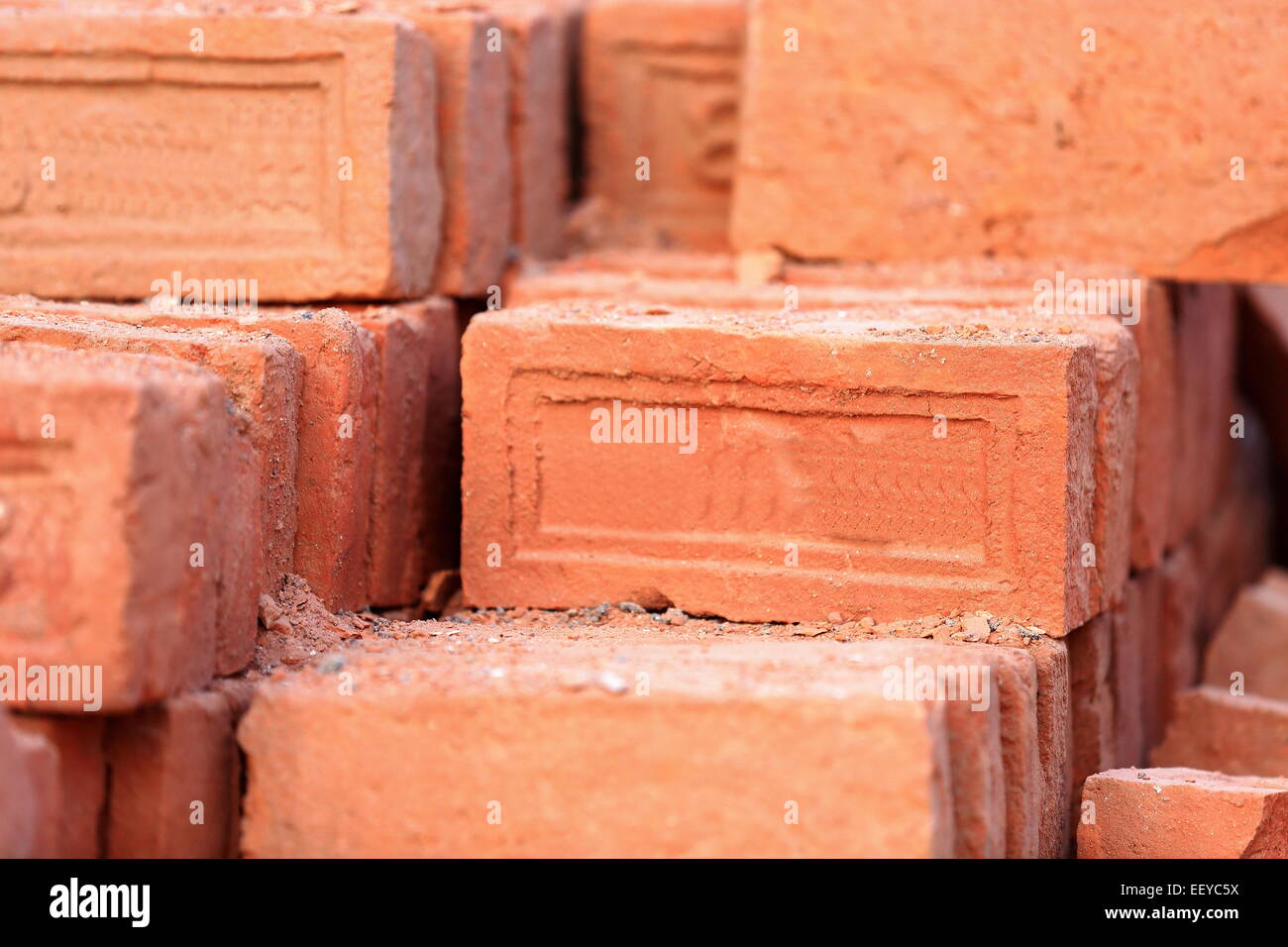Building materials: red bricks for construction piled on the floor of a ...