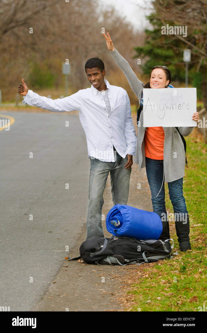 Two people hitchhiking Stock Photo - Alamy