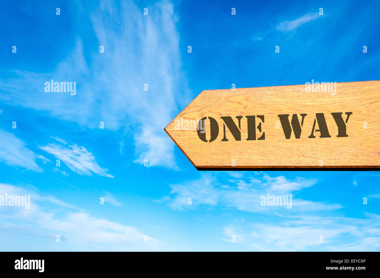 Wood arrow sign against clear blue sky with One Way message Stock Photo ...