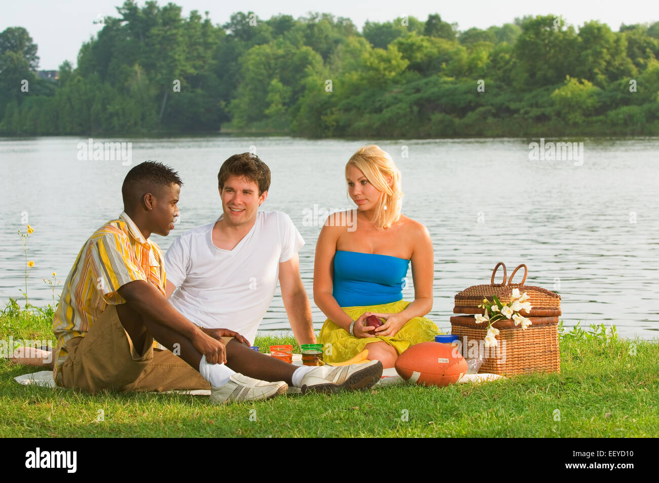 Three friends having a picnic by the water Stock Photo - Alamy