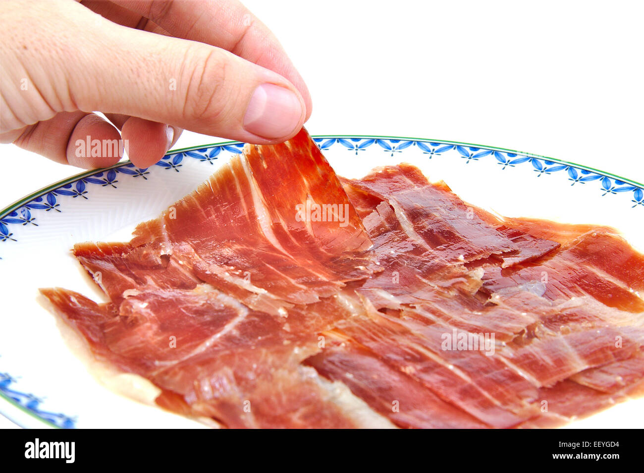 Man's hand holding an spanish serrano ham slice Stock Photo - Alamy