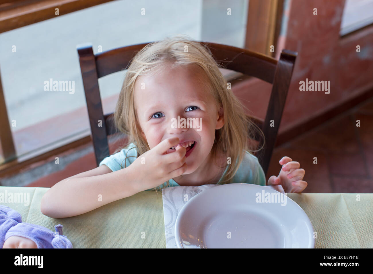 Adorable little girl having breakfast at restaurant Stock Photo - Alamy