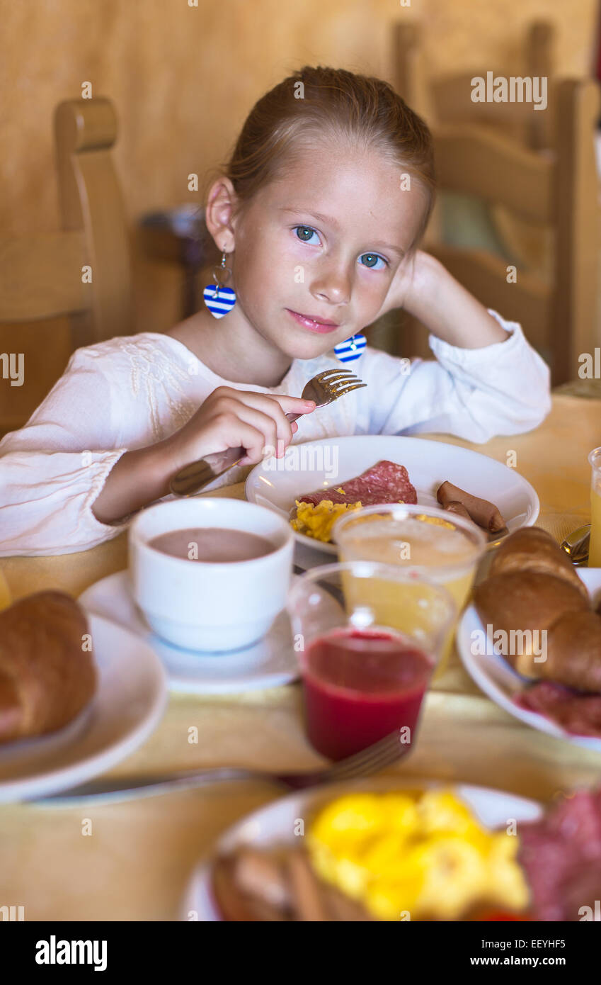 Adorable little girl having breakfast at indoor cafe Stock Photo - Alamy