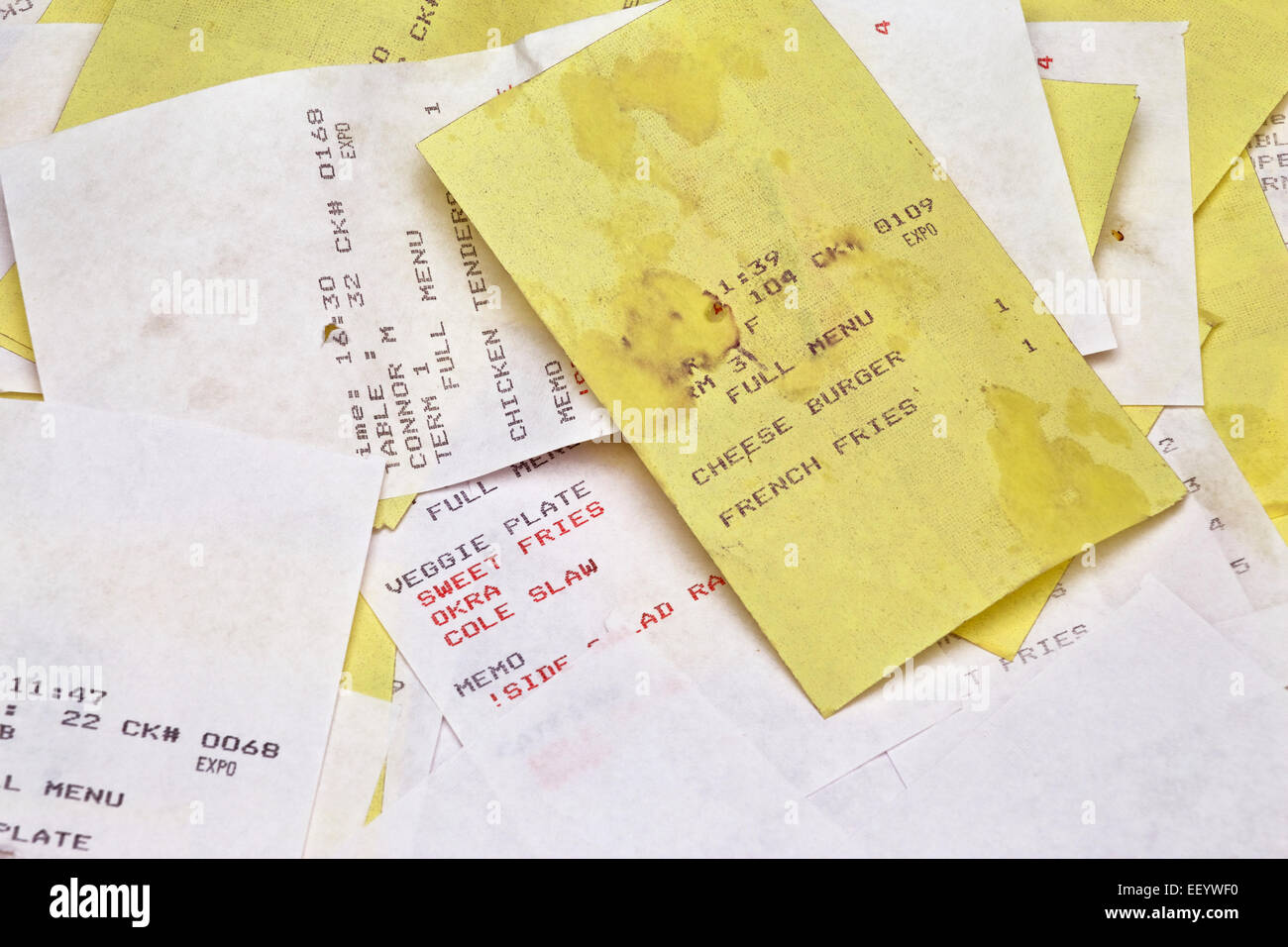 Yellow grease stained restaurant food order tickets in messy pile Stock ...