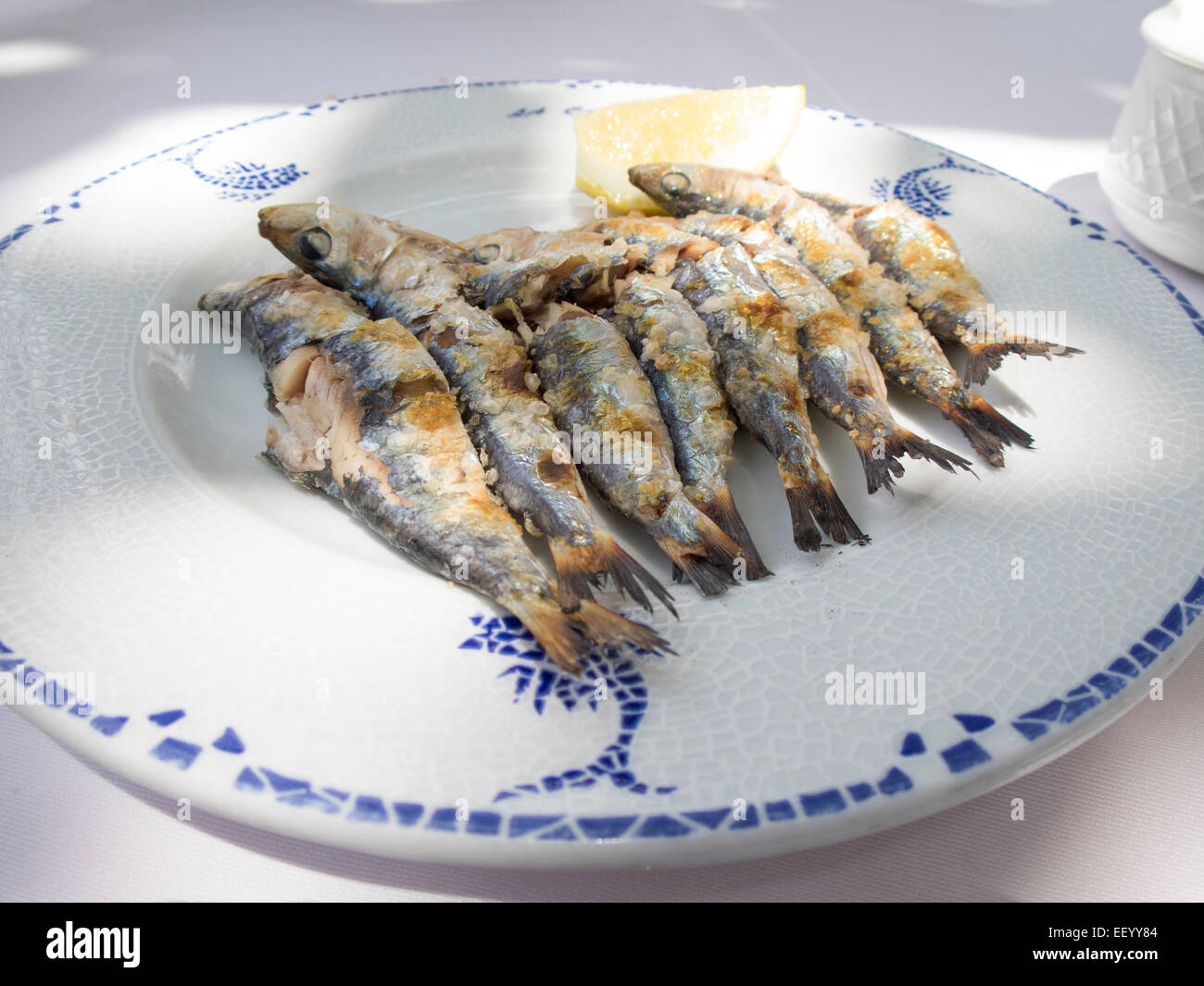 typical spanish barbecue espeto sardines in white and blue dish on ...