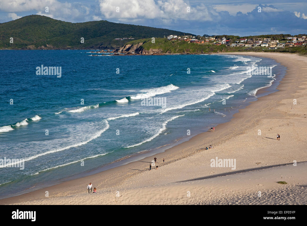 Tourists walking along One Mile Beach at Forster along the Tasman Sea ...