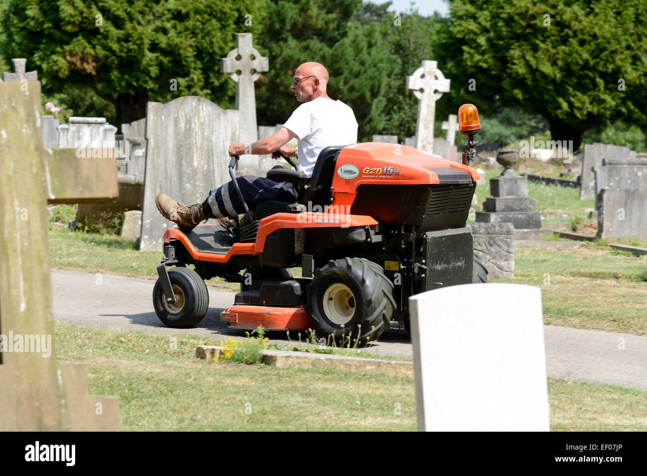 Man driving sit-on lawnmower at Foster Hill Road Cemetery, Bedford ...