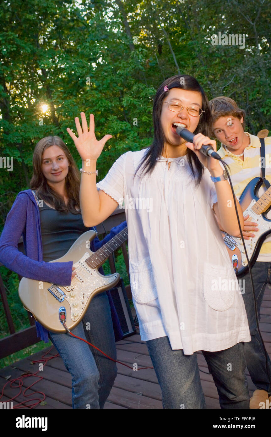 Girl singing into microphone Stock Photo - Alamy