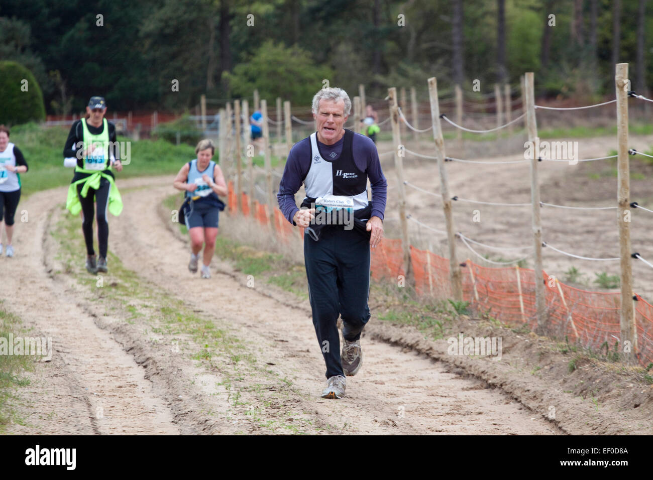Runners in a coastal cross-country race on a sandy unmade road Stock ...