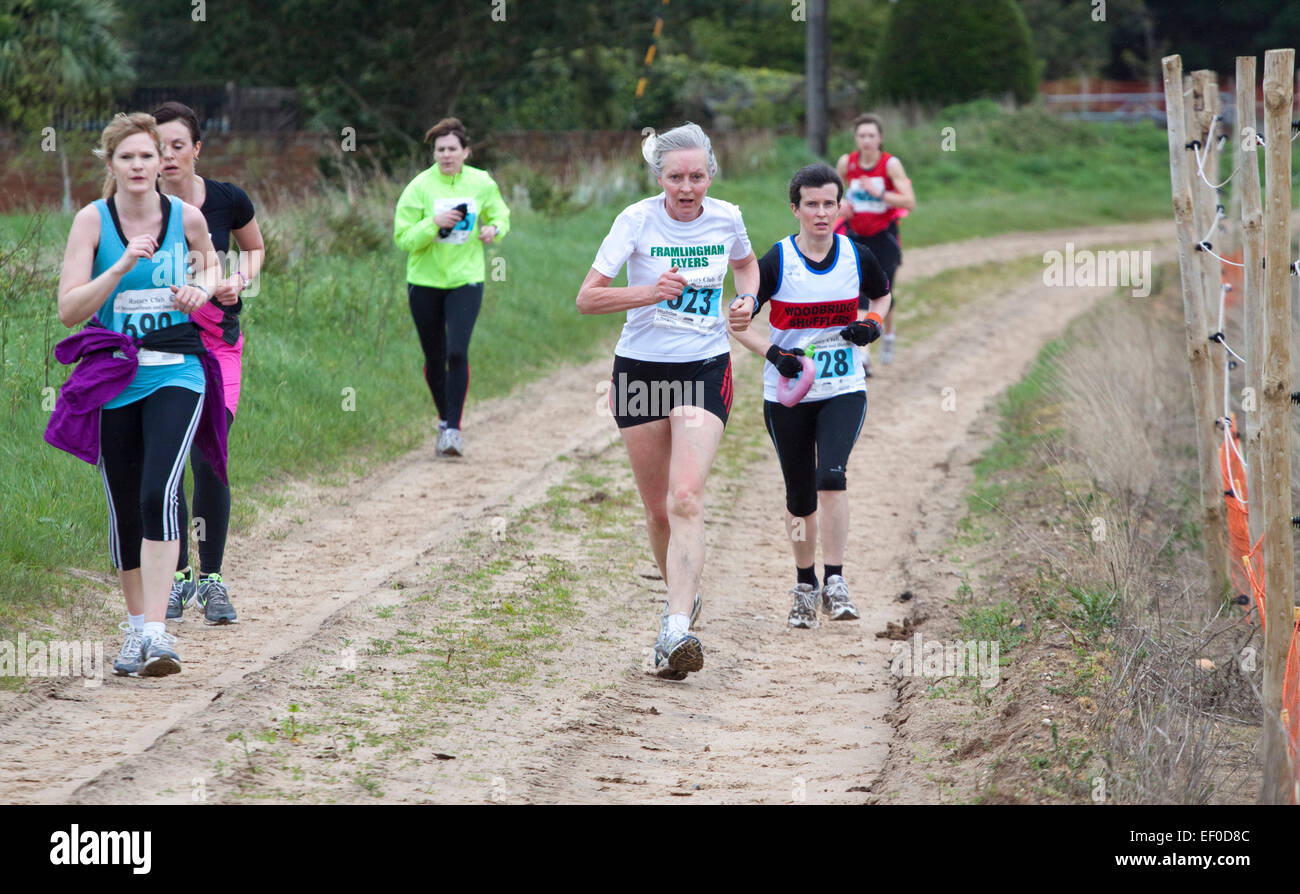 Runners in a coastal cross-country race on a sandy unmade road Stock ...
