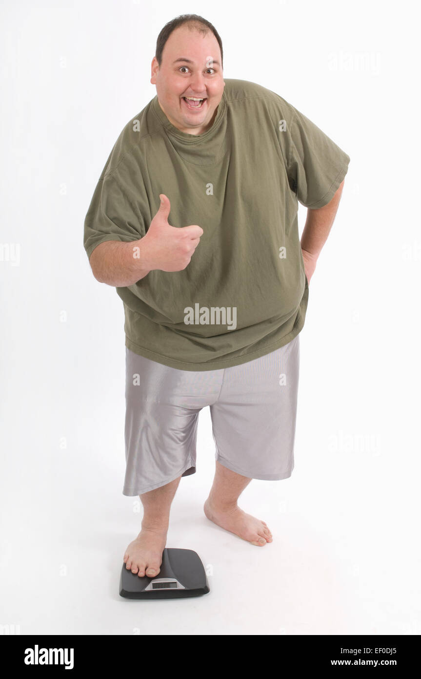 Overweight man standing on a scale Stock Photo - Alamy