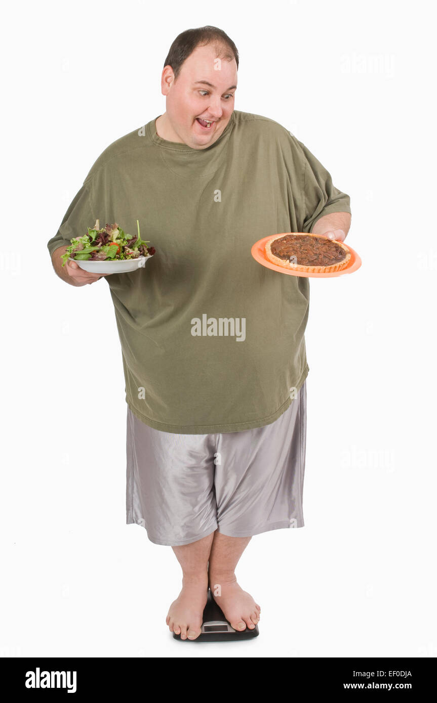 Overweight man standing on a scale Stock Photo - Alamy