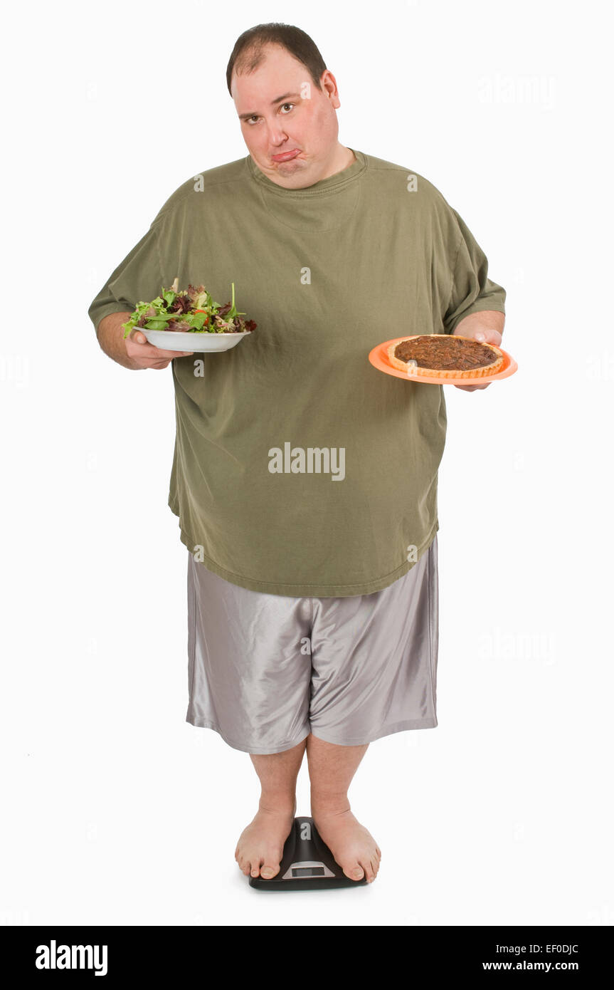 Overweight man standing on a scale Stock Photo - Alamy
