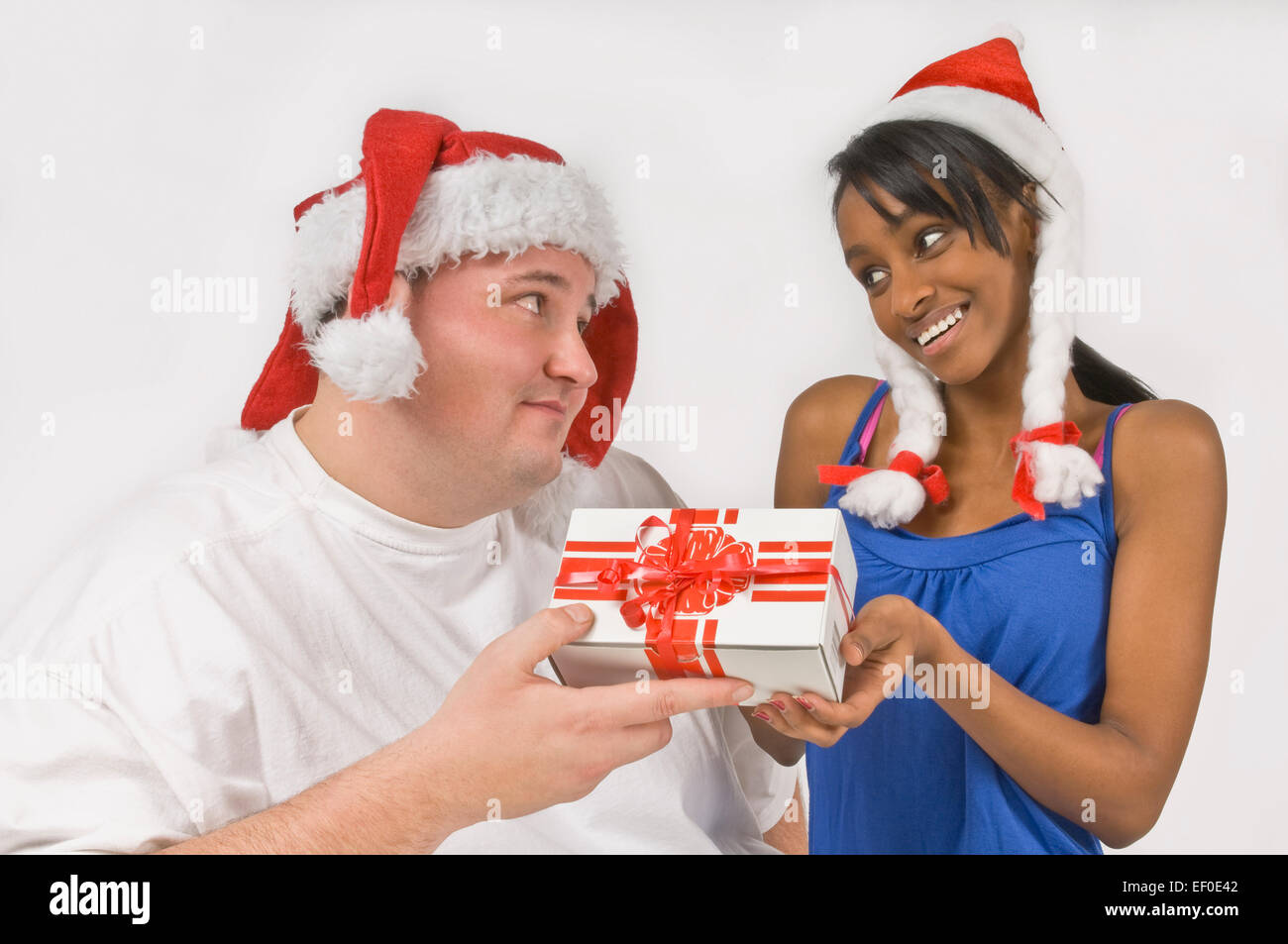 Overweight man giving Christmas present to slim woman Stock Photo - Alamy
