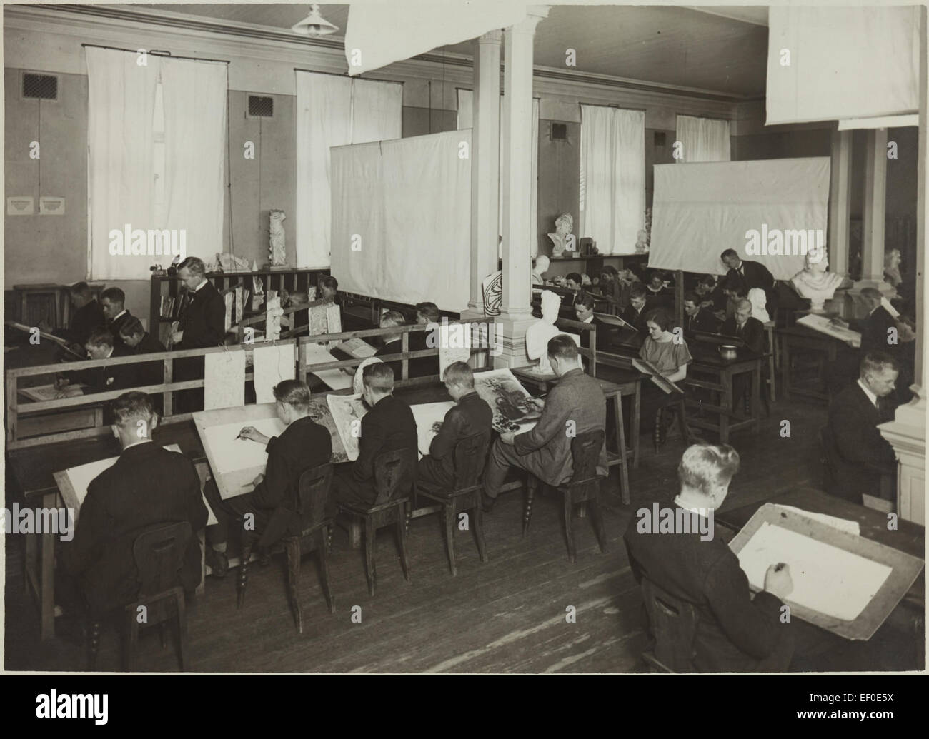 This image captures students in a drawing class, where they are ...