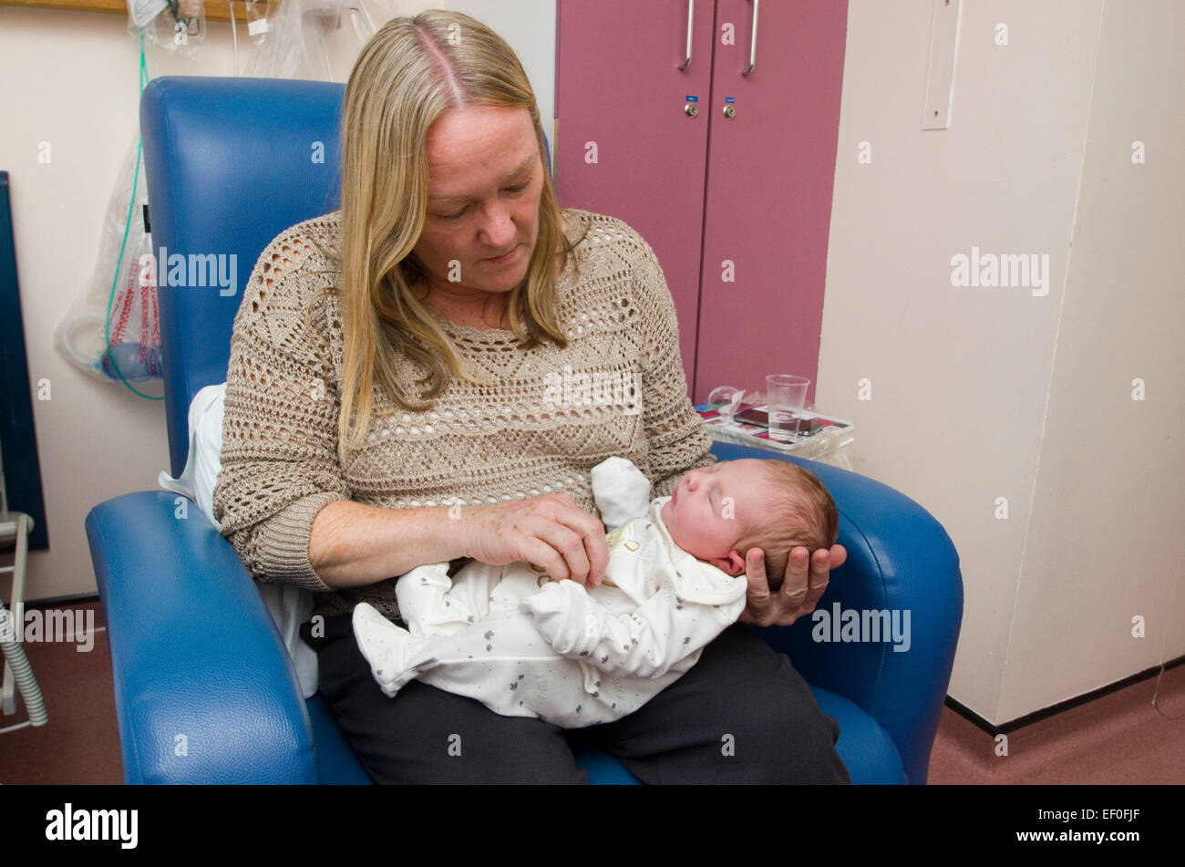 A new born baby in a hospital being closely held by its grandmother ...