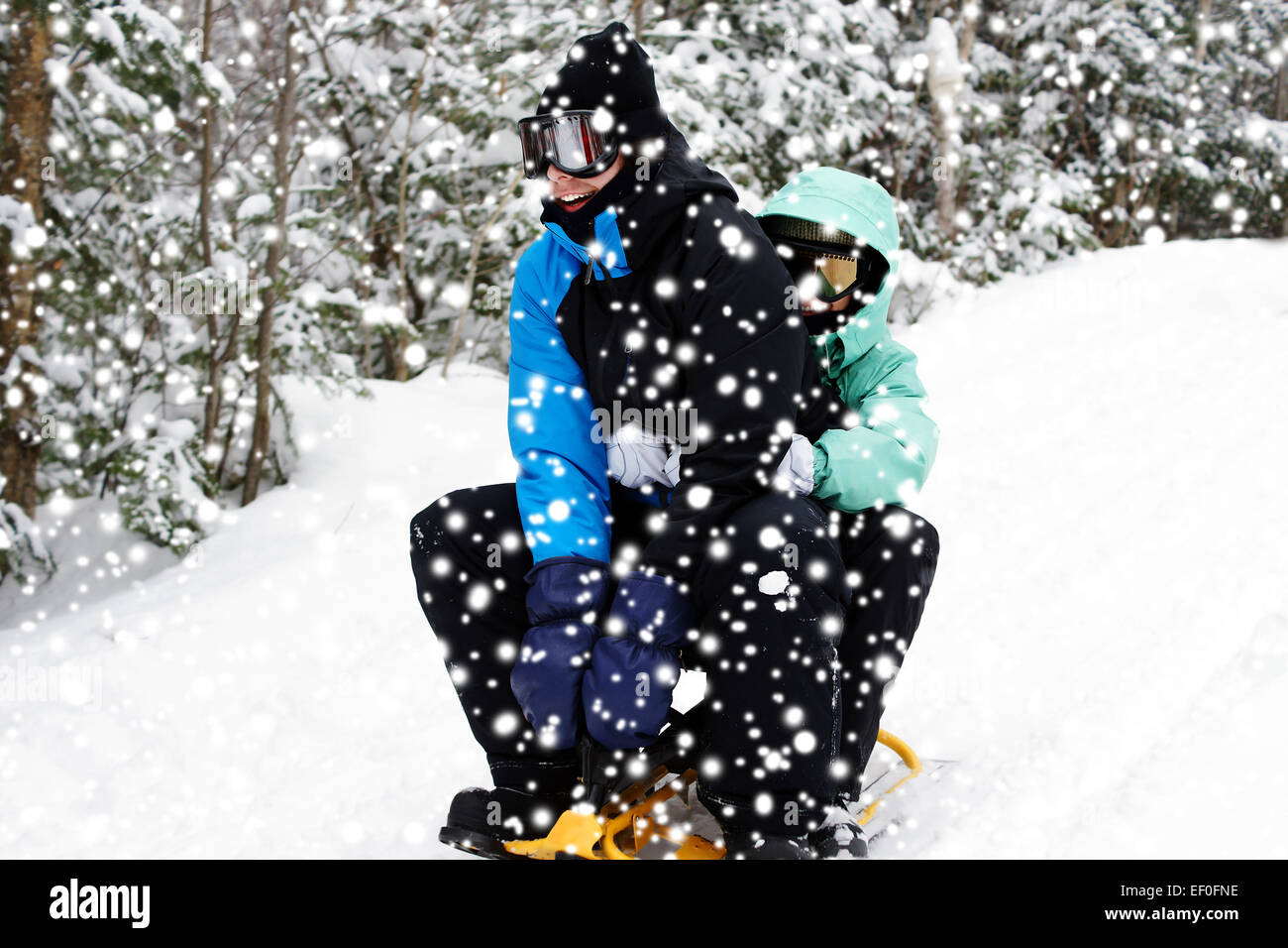 Young couple having fun sliding on the snow, winter sport concept Stock ...
