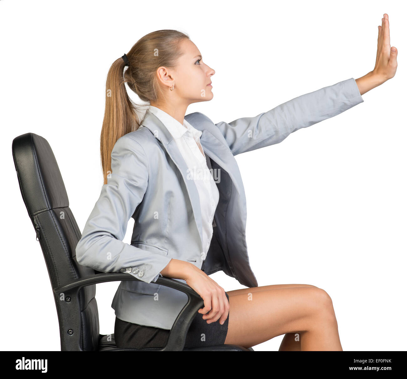 Businesswoman on office chair, with her hand reached upwards and ahead ...